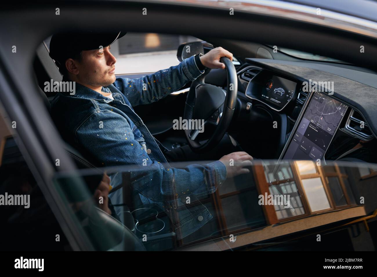 View through open side car window. Man in cap sitting in elite ...