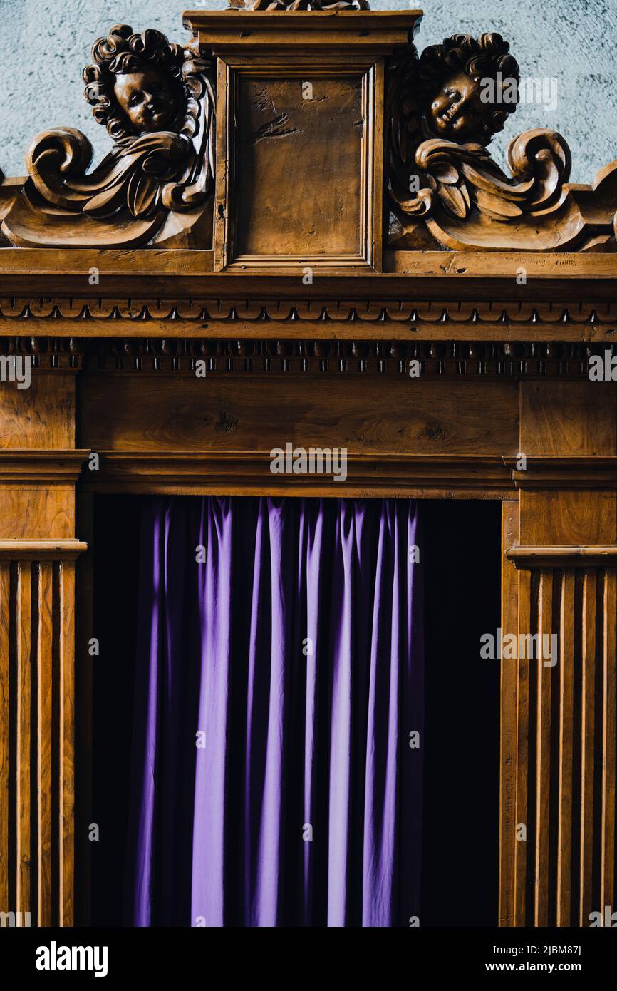 Typical old wooden confession booth at a church, with blue curtains ...