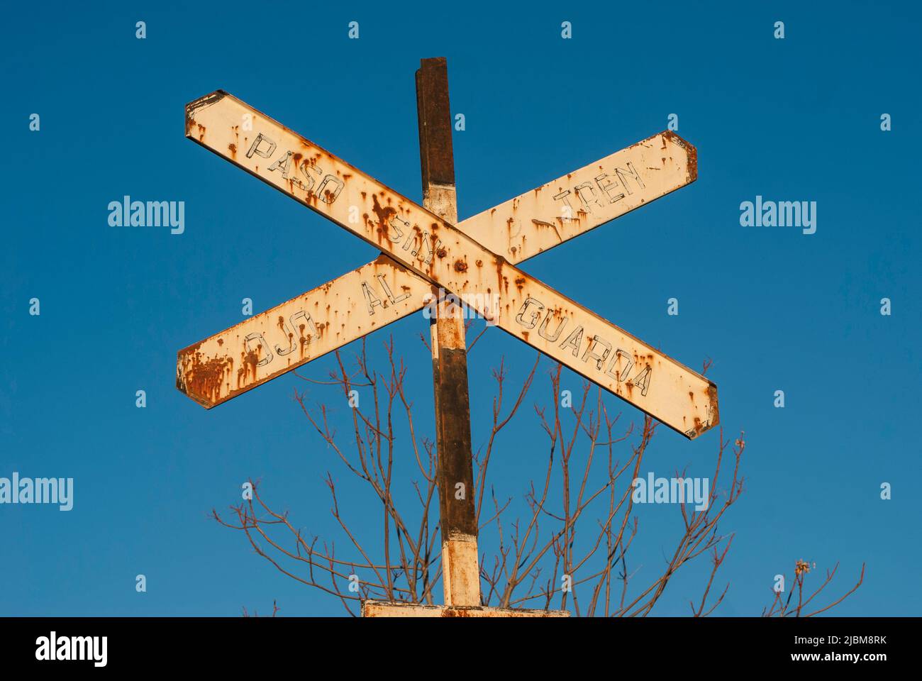 Train level crossing sign with blue sky in horizontal Stock Photo - Alamy