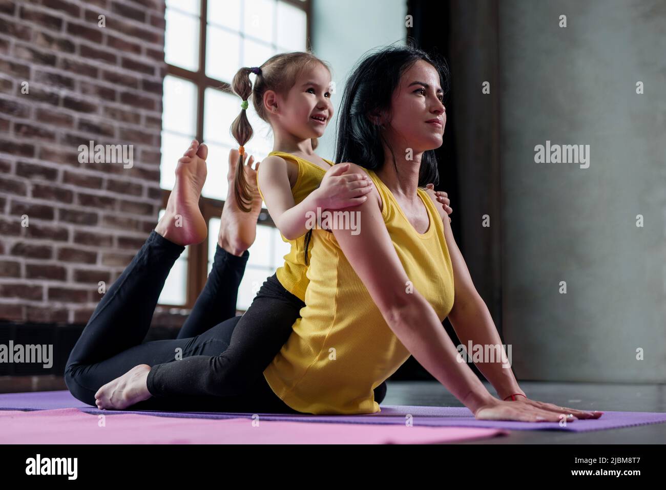Young Caucasian woman doing stretching exercise for spine together with ...