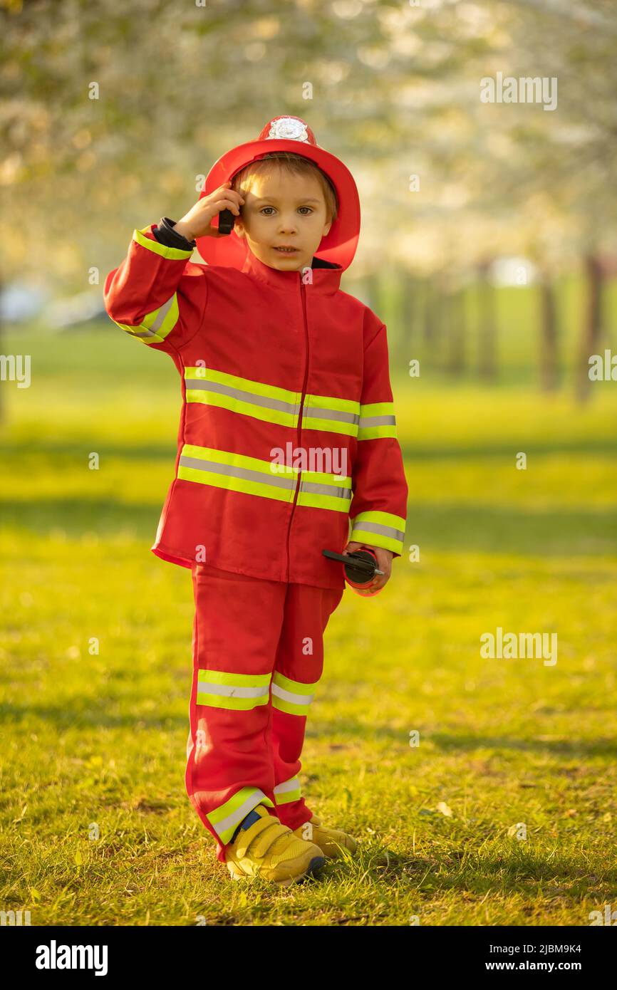 Little toddler child with fireman costume in park, pretending to be ...