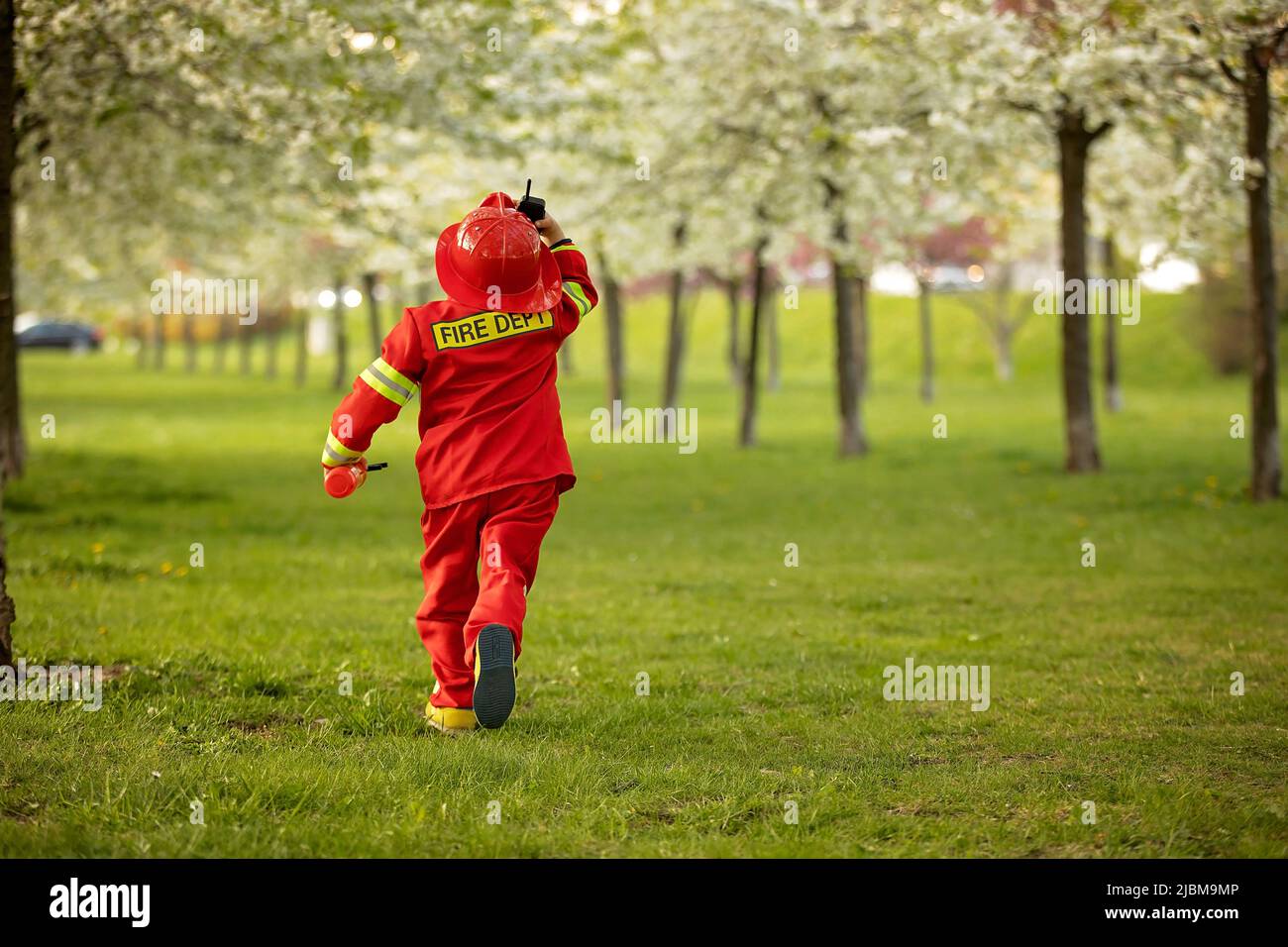 Little toddler child with fireman costume in park, pretending to be ...