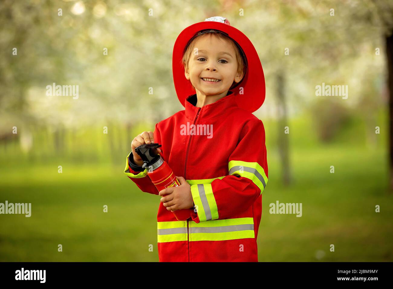 Little toddler child with fireman costume in park, pretending to be ...