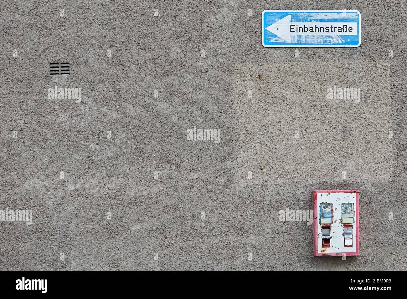 vintage gumball machine fixed on a wall and a German one way sign Stock ...