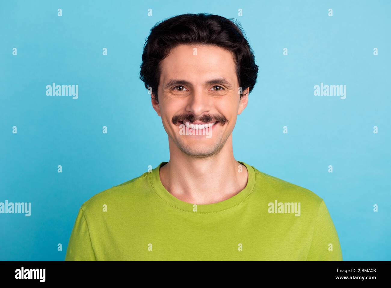 Photo of attractive funny cheerful guy dressed green t-shirt smiling ...