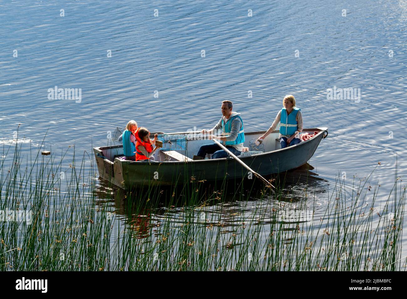 Family cray-fishing in a boat Stock Photo - Alamy