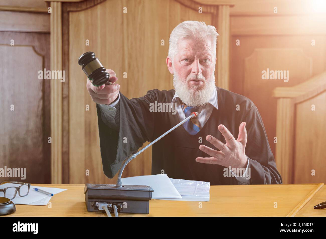 a serious judge holds a judge's gavel in court Stock Photo - Alamy