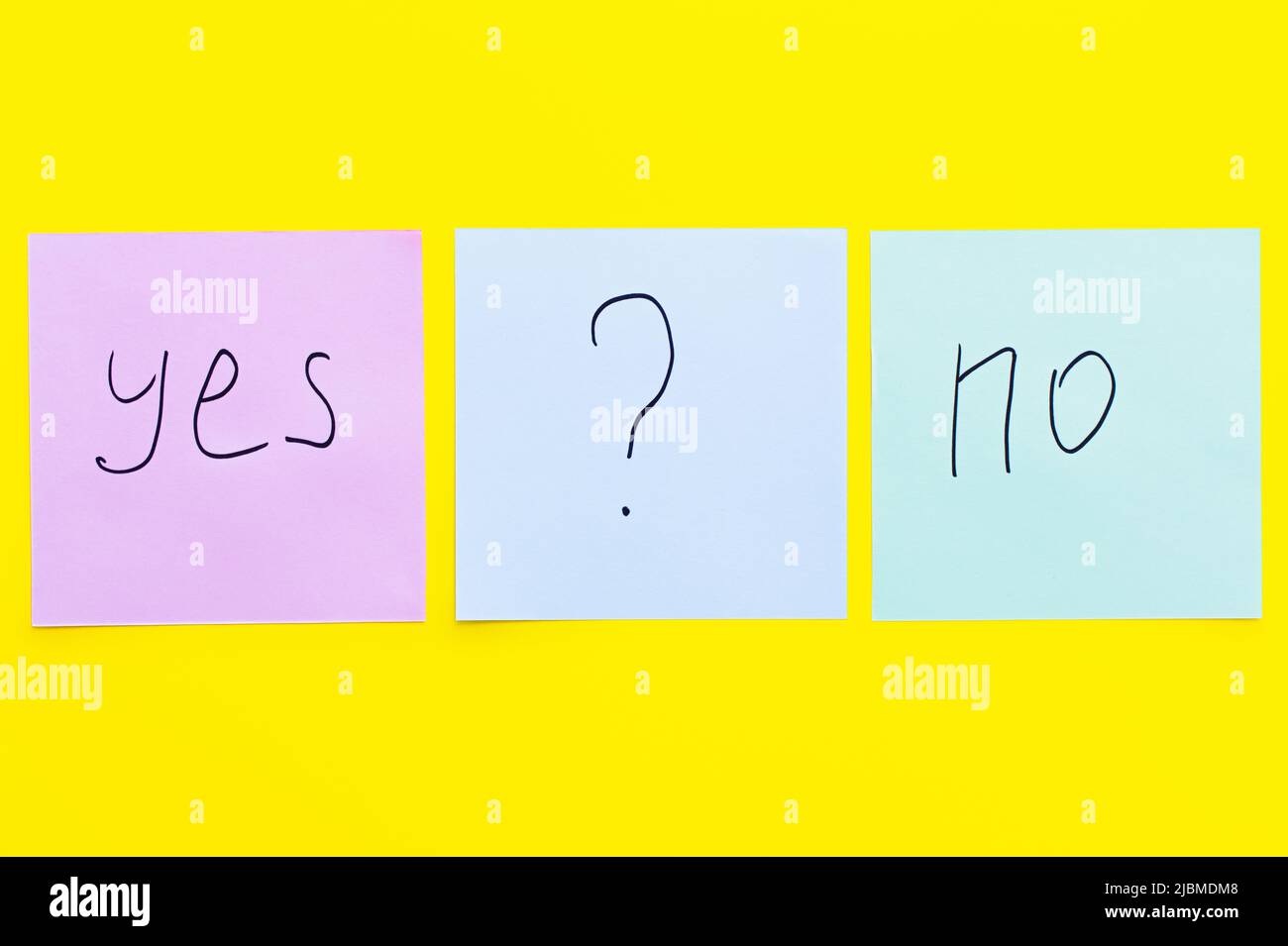 top view of sticky notes with question mark between yes and no words on ...