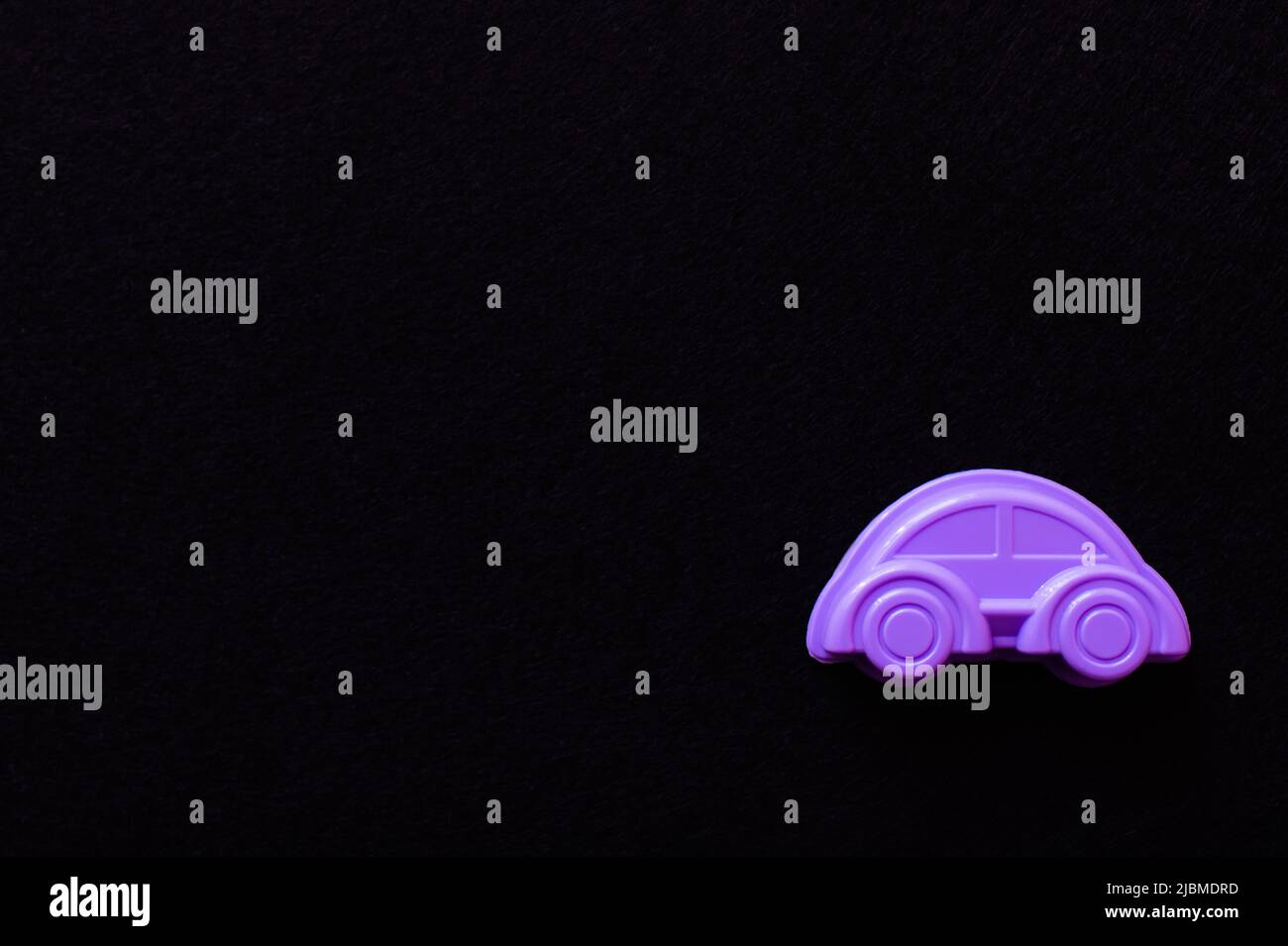 top view of bright purple toy car isolated on black with copy space ...