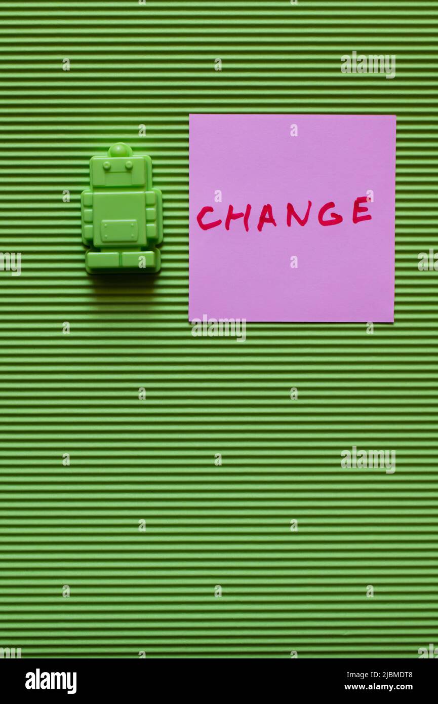 top view of toy robot near purple paper with change inscription on ...