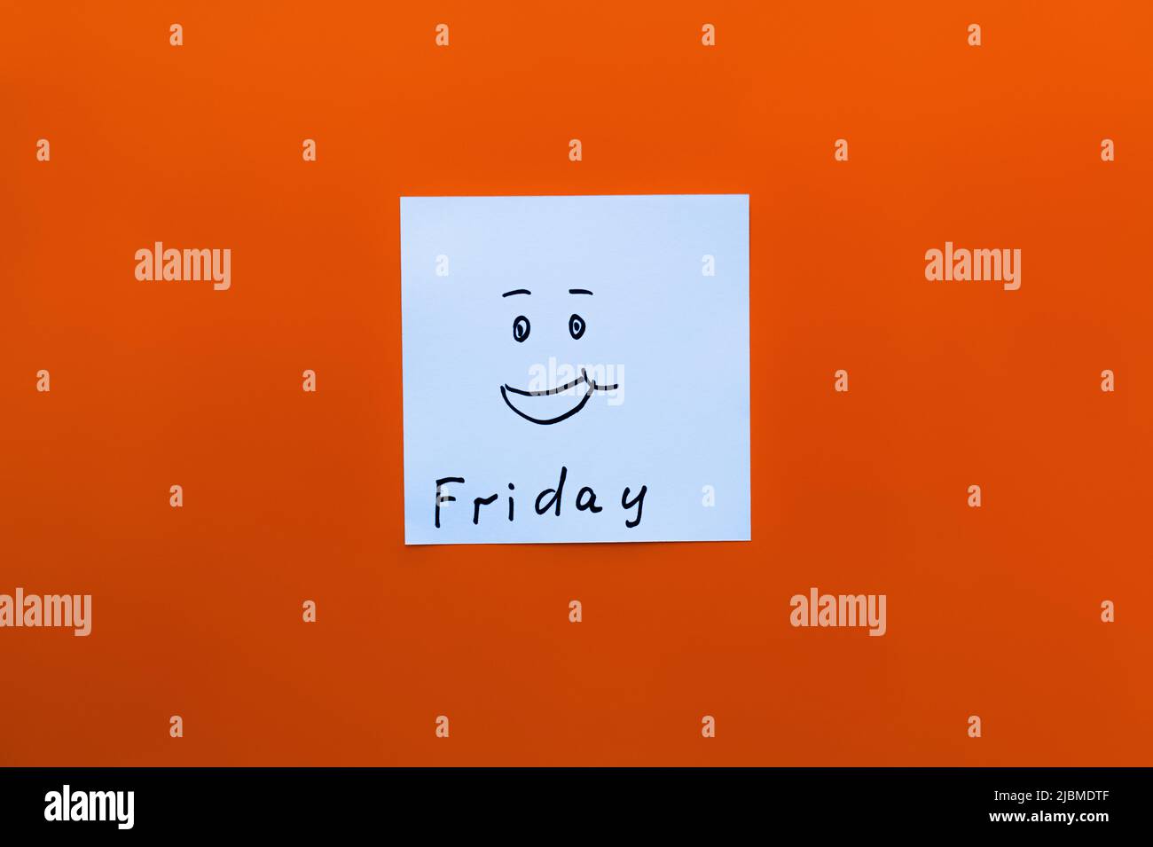 top view of card with friday lettering and happy emoticon on orange ...