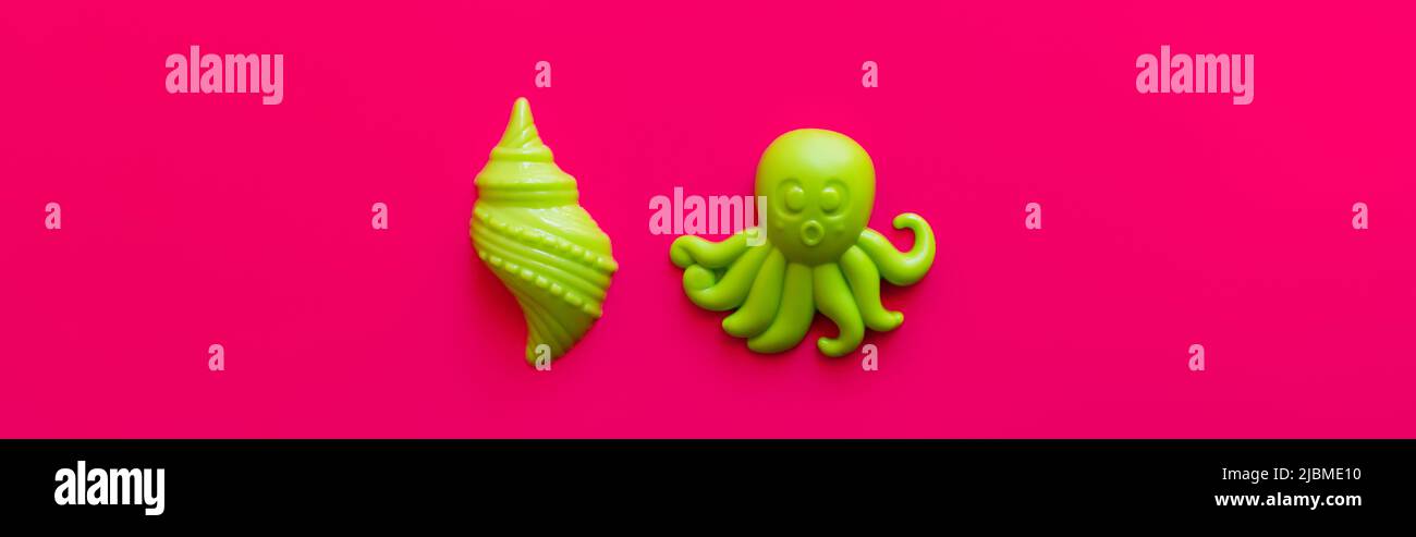 top view of bright green shellfish and octopus toys on pink background ...