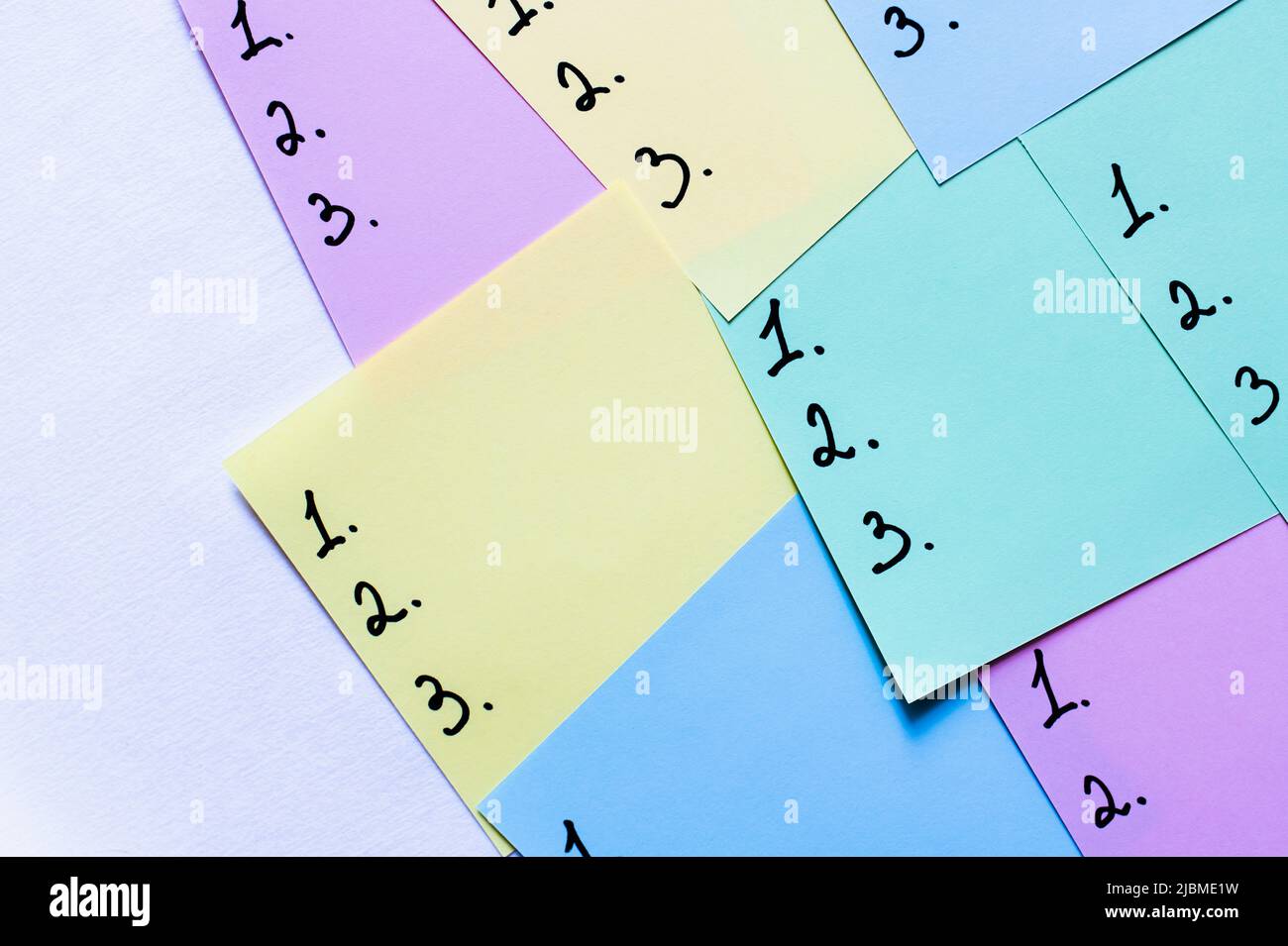 top view of multicolored sticky notes with numbers on white background ...