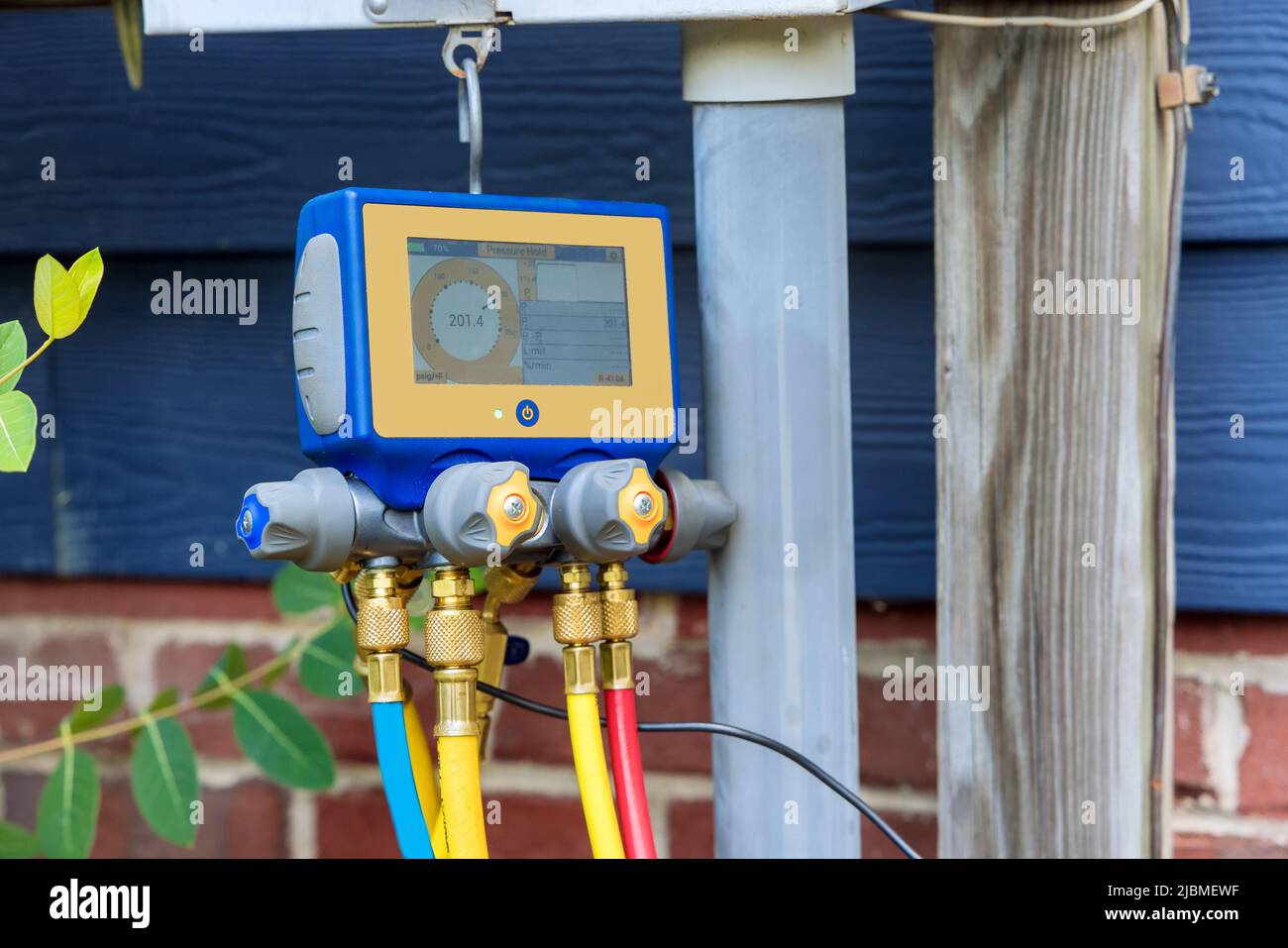 Technician examining air conditioner with multimeter measuring ...