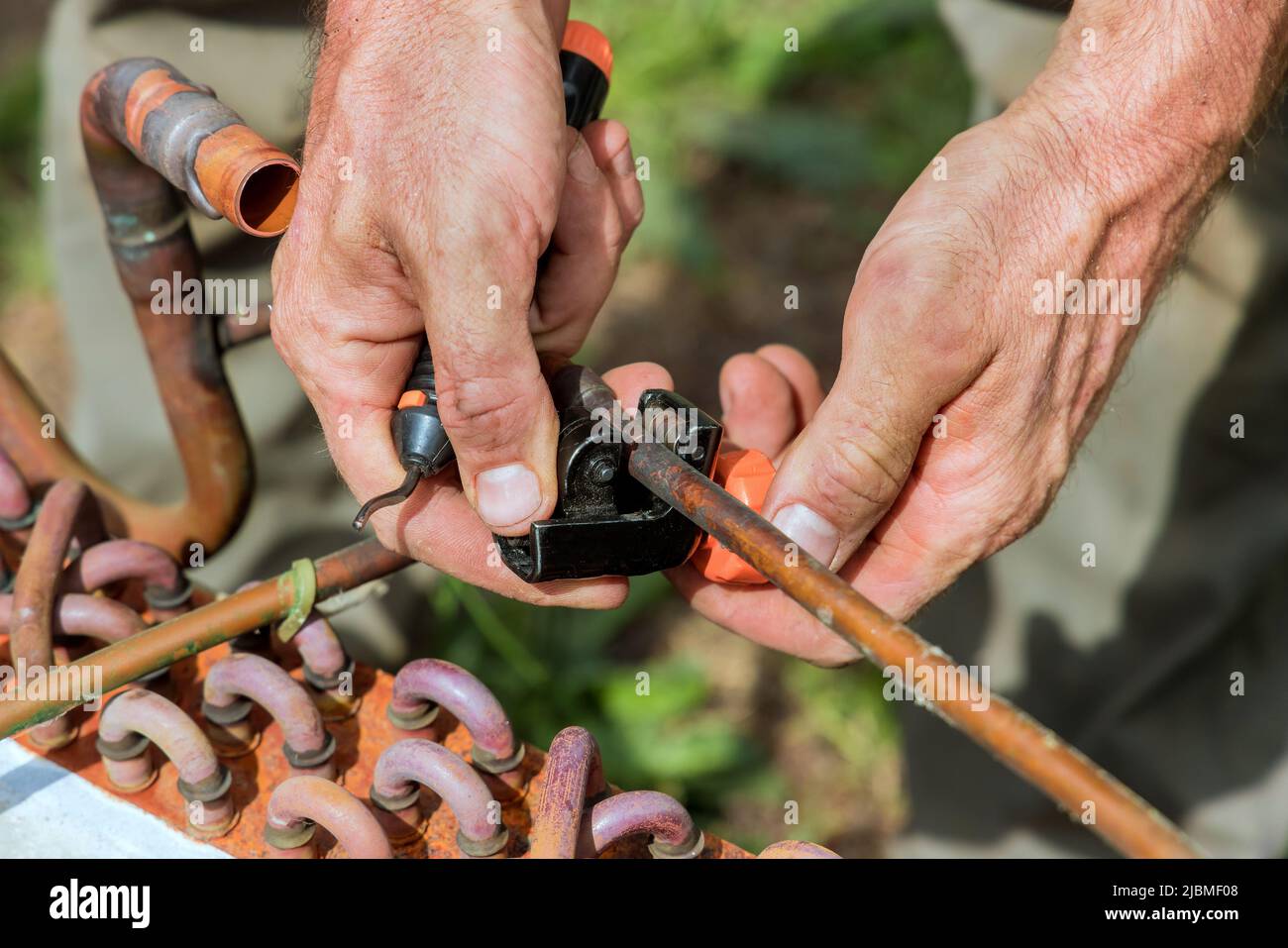 Closeup worker plumber the cutting a copper pipe Stock Photo - Alamy