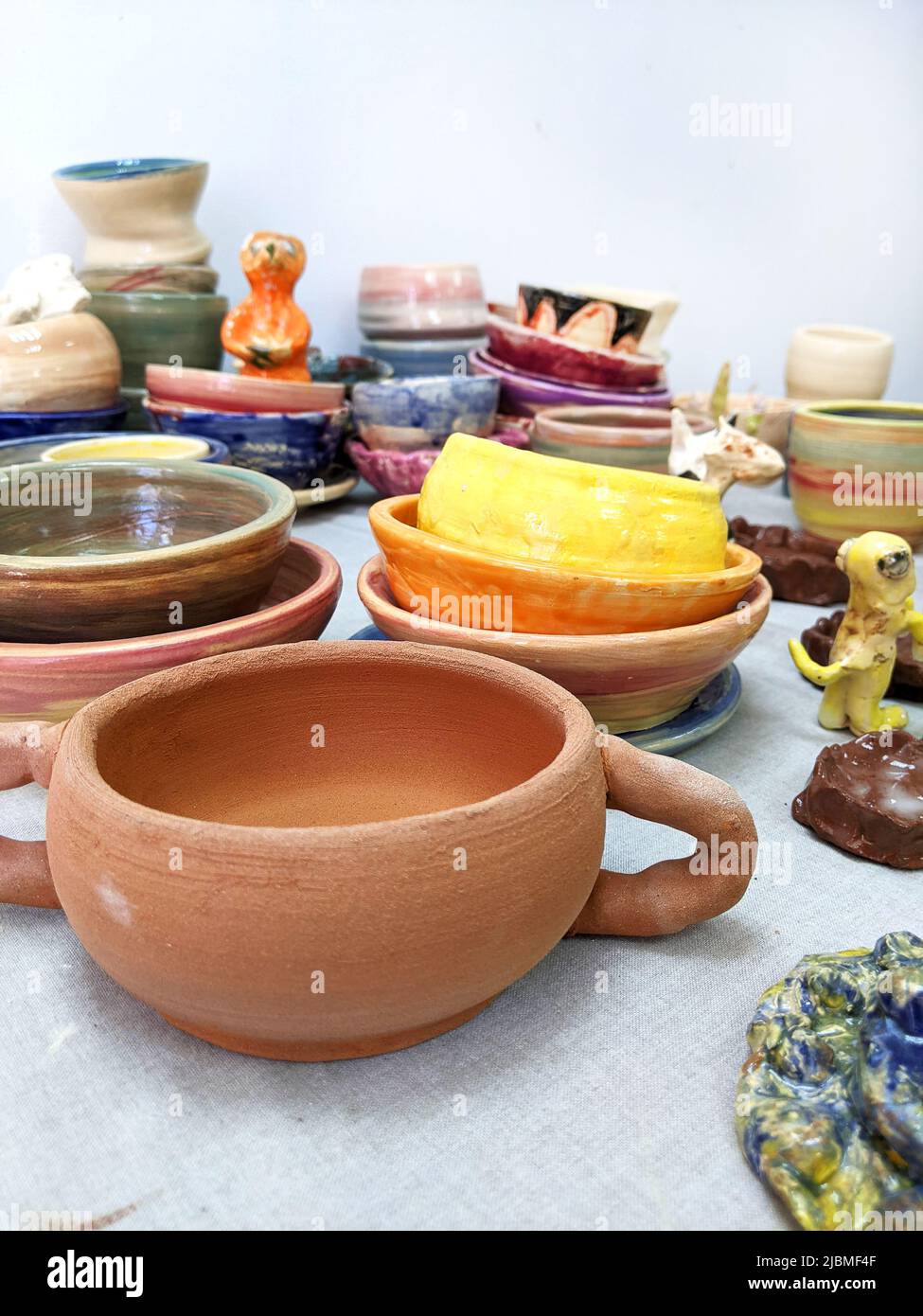 Ceramic cups, mugs and pots on a table in a pottery workshop Stock ...