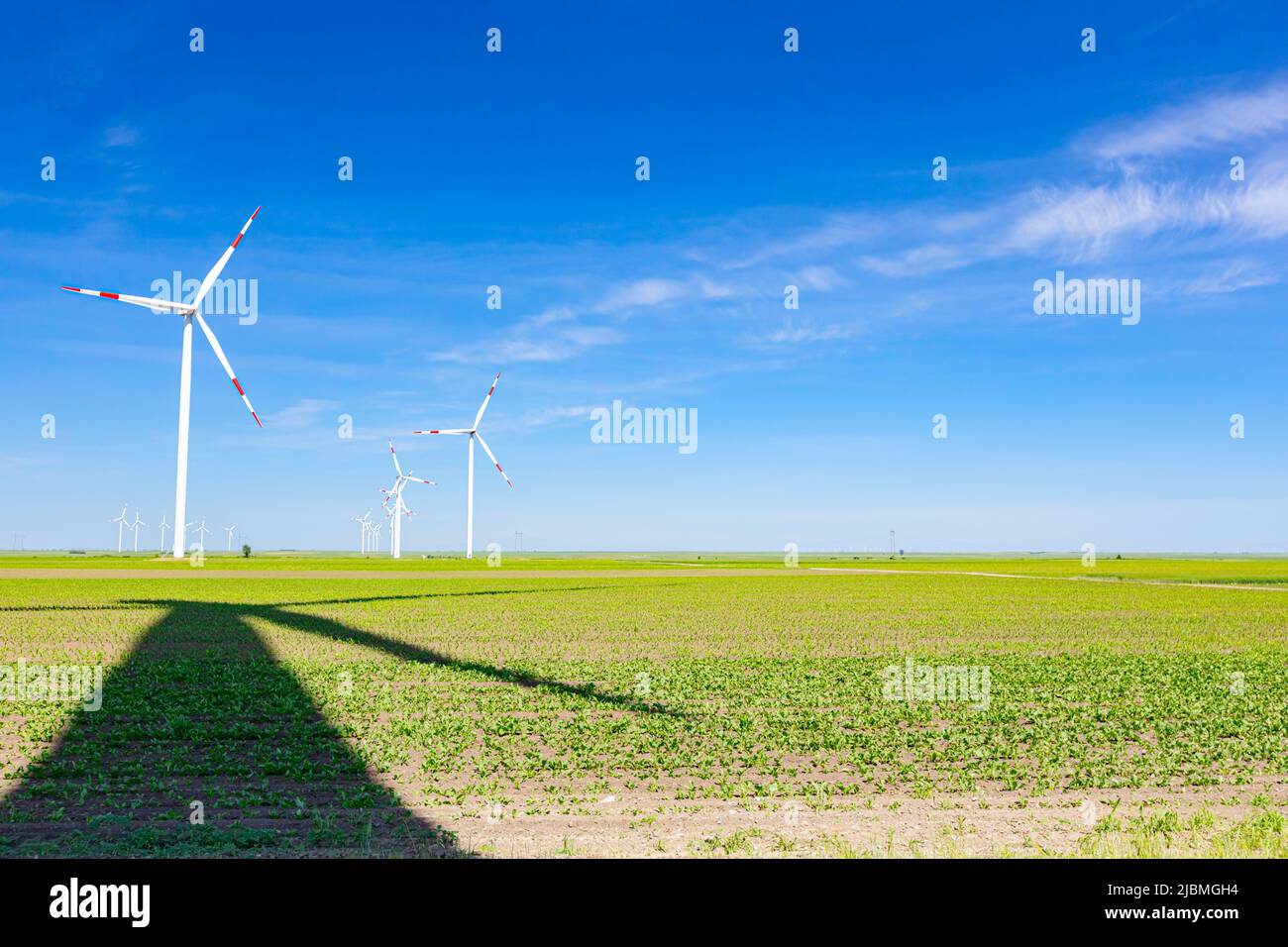 Long shadow under wind generator, turbines, with rotating blades ...