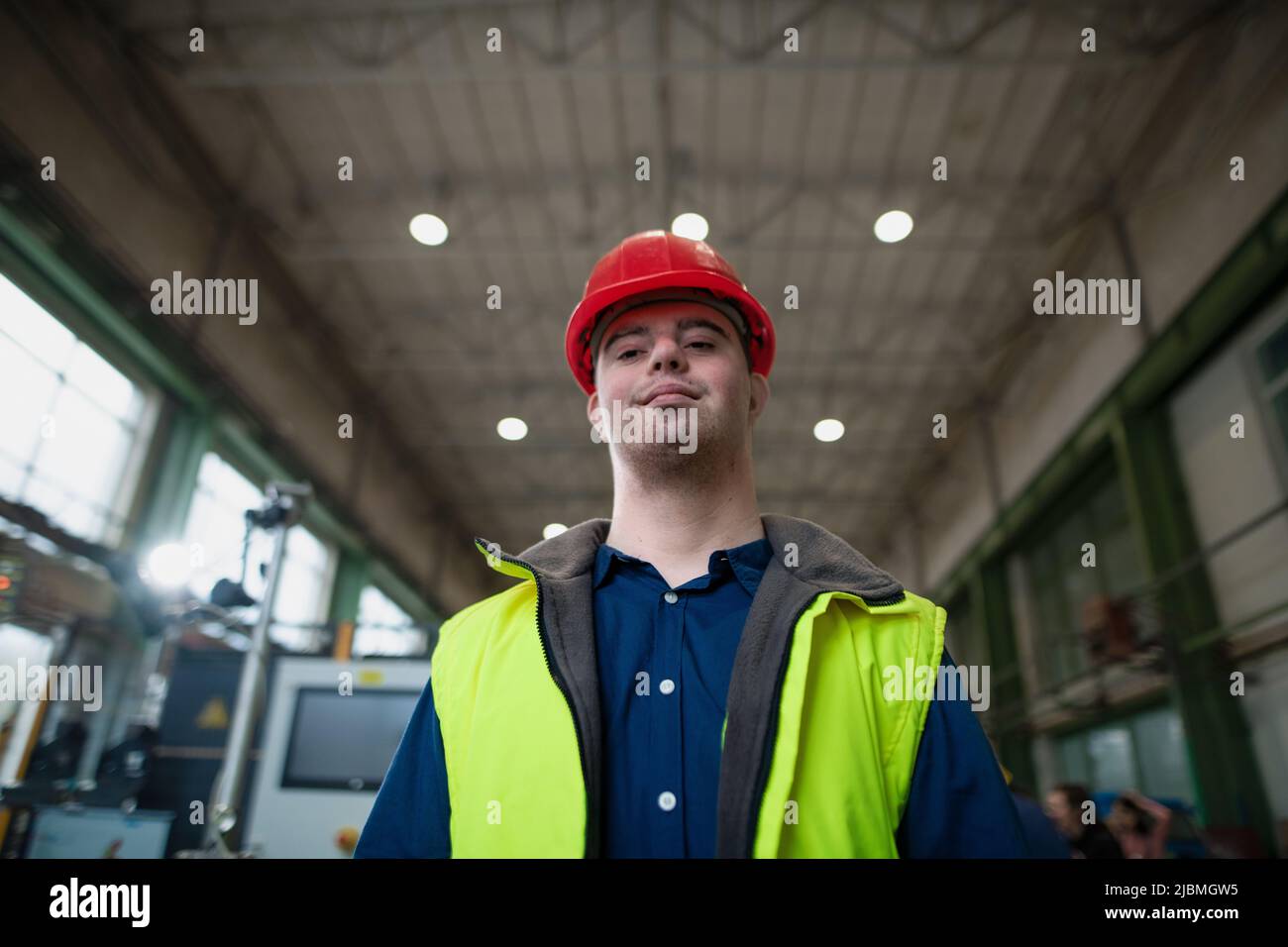 Young man with Down syndrome working in industrial factory, social ...