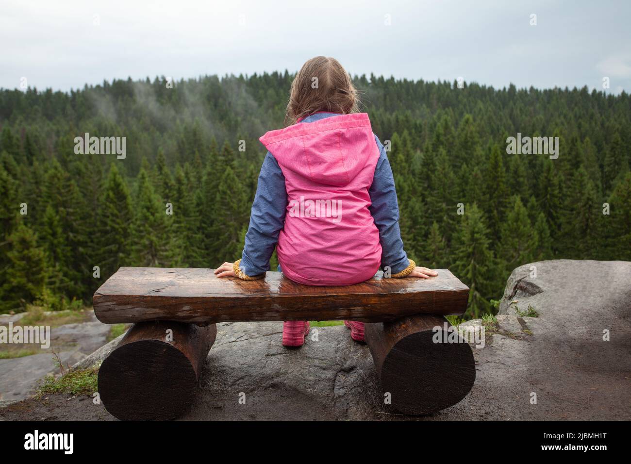 Little kid girl resting on a bench outdoors Stock Photo - Alamy