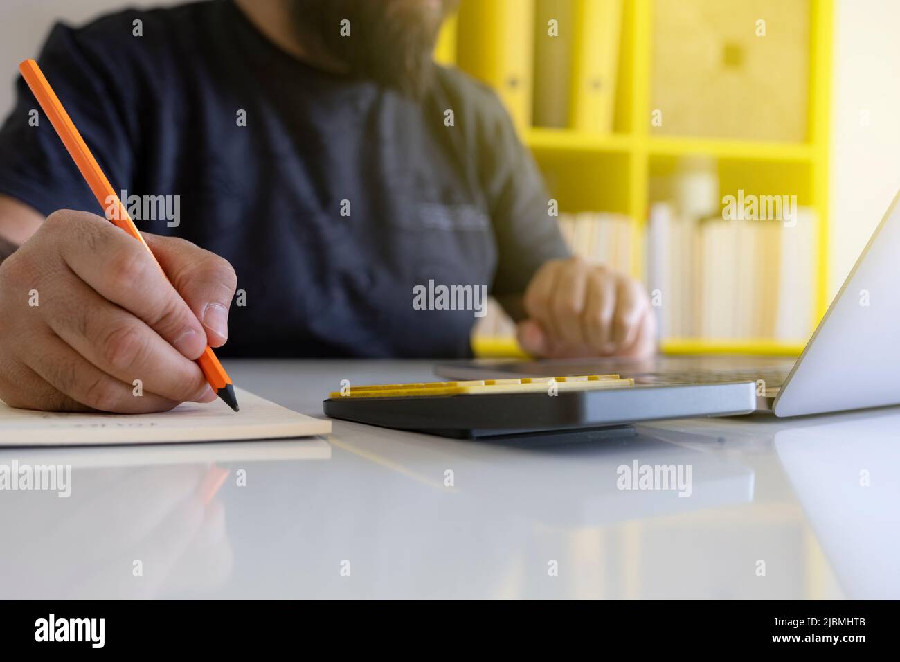 Using laptop and taking notes, close up of man's hand using laptop and ...