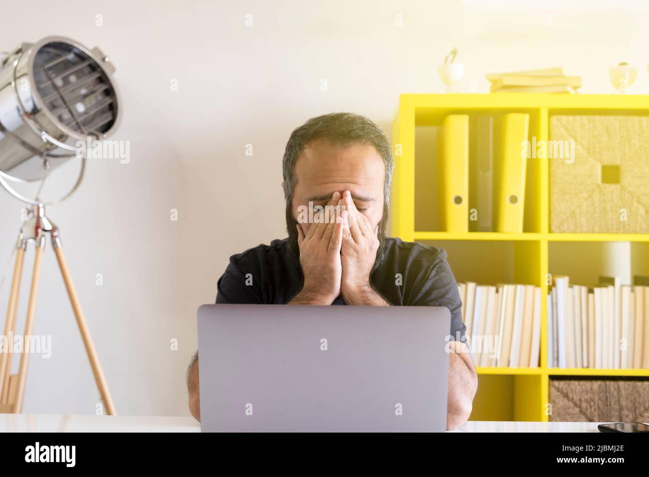 Stressed young man, front view of stressed young man, covering face ...