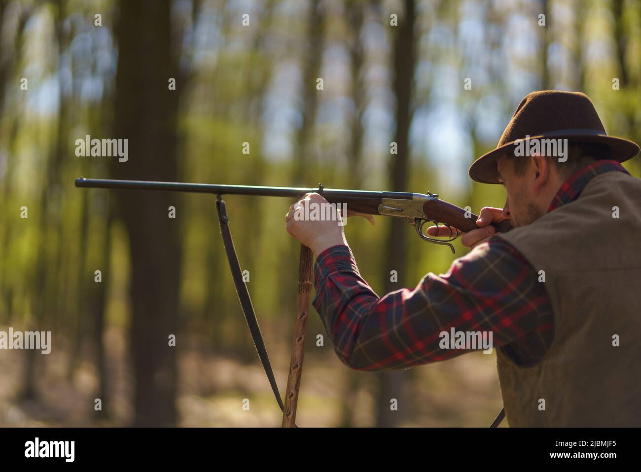 Hunter man aiming with rifle gun on prey in forest Stock Photo - Alamy
