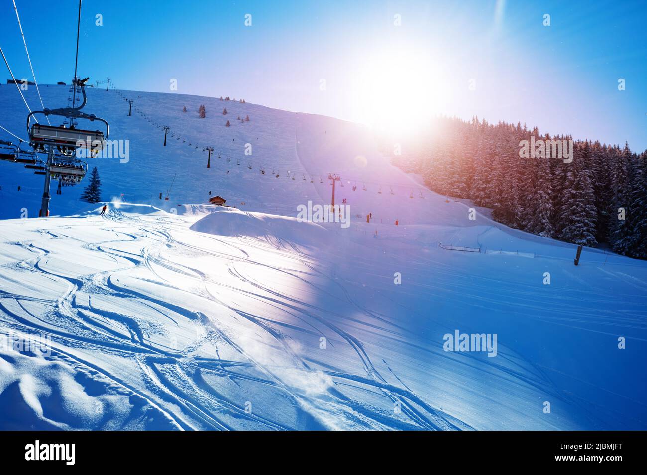 Ski lift on alpine resort with sunset over mountain range Stock Photo ...