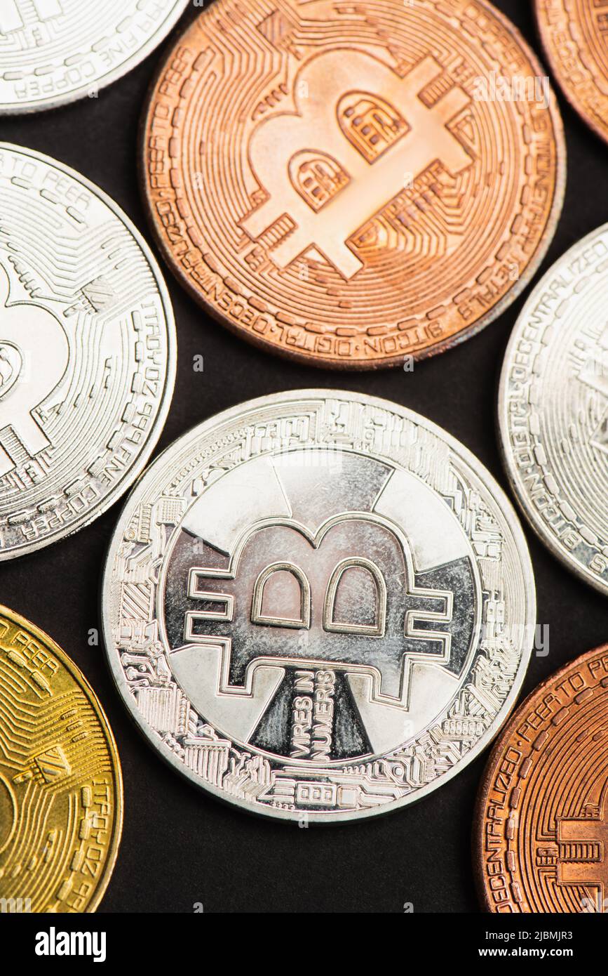 KYIV, UKRAINE - APRIL 26, 2022: Top view of different bitcoins on black ...