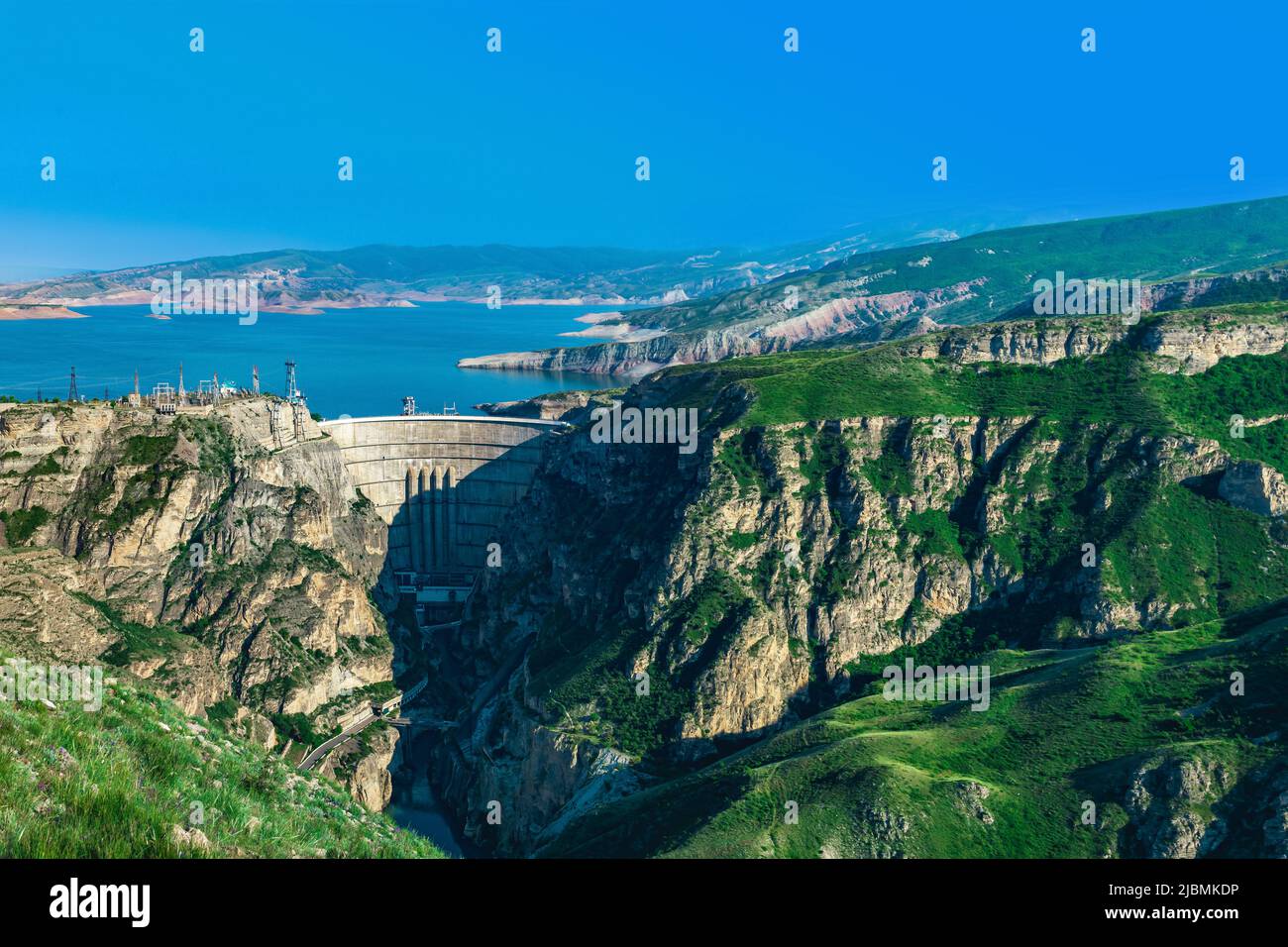 mountain landscape with an arched hydroelectric dam in the canyon and a ...