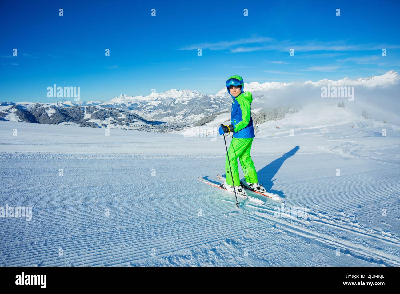 Preteen boy stand on alpine ski look back and smile Stock Photo - Alamy
