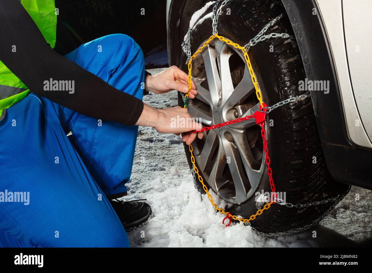 Man hands close-up putting chains on the car wheel Stock Photo - Alamy