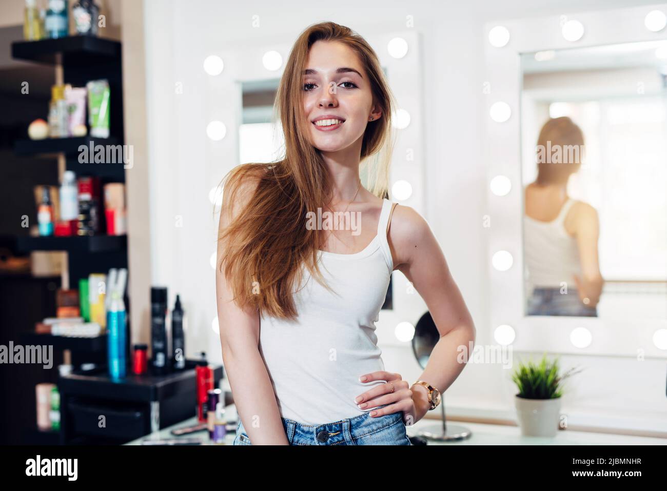 Portrait of pretty female beautician standing posing at workplace in ...
