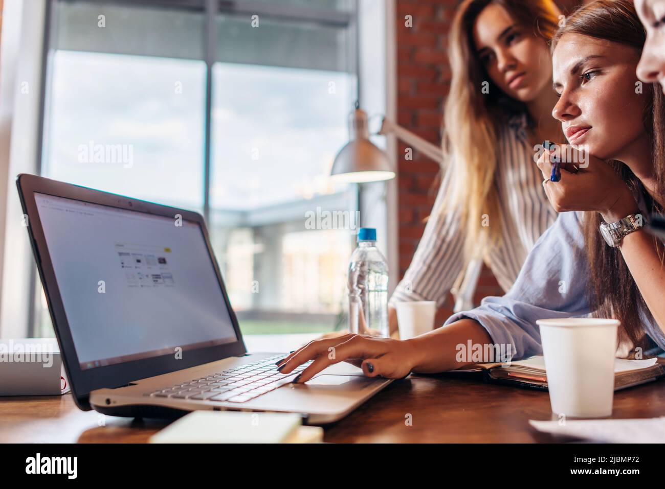 Group of office workers using a laptop together Stock Photo - Alamy