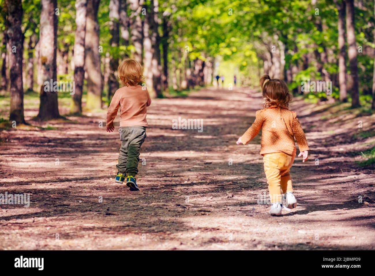 Little girl playing behind a tree hi-res stock photography and images ...