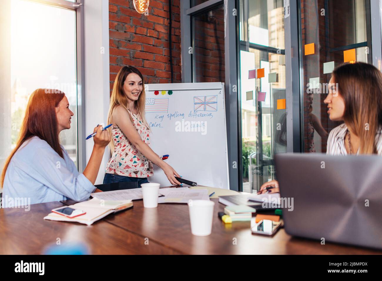 Young woman teaching English to adult students at language school Stock ...