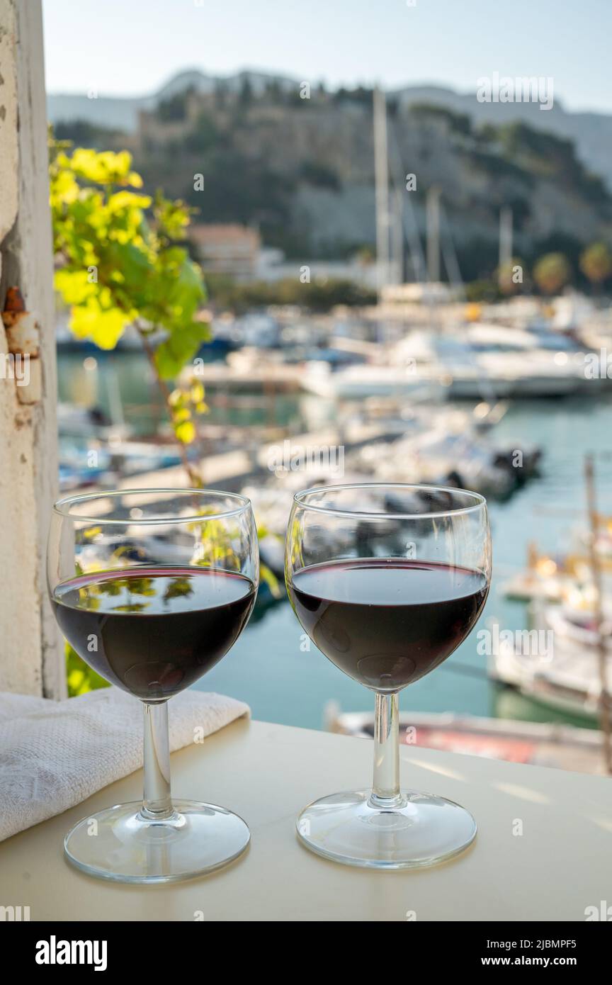 Drinking of red dry wine on outdoor terrace with view on old fisherman ...