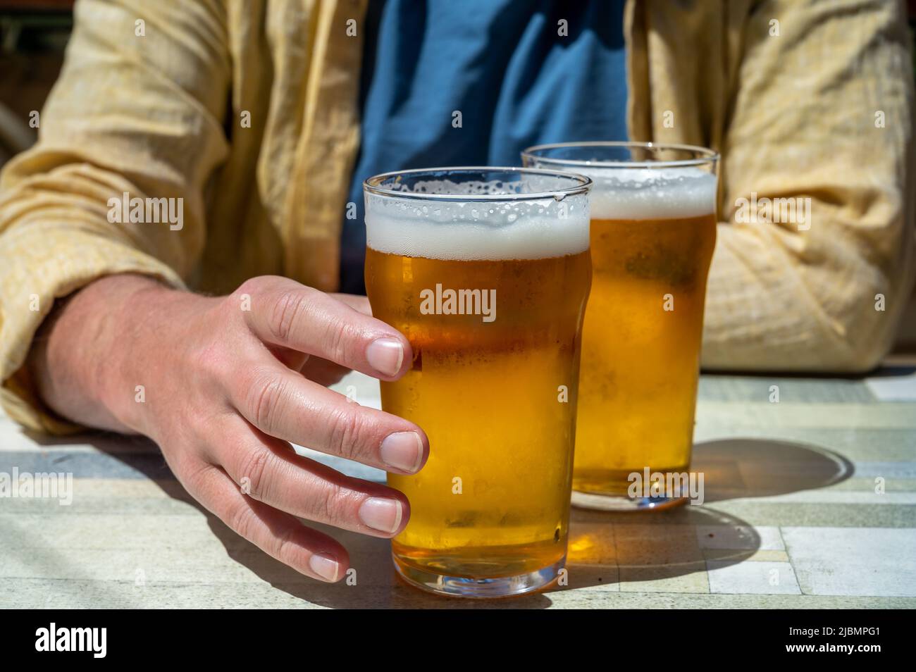 Men with two glasses of fresh cold lager beer in French outdoor cafe in ...