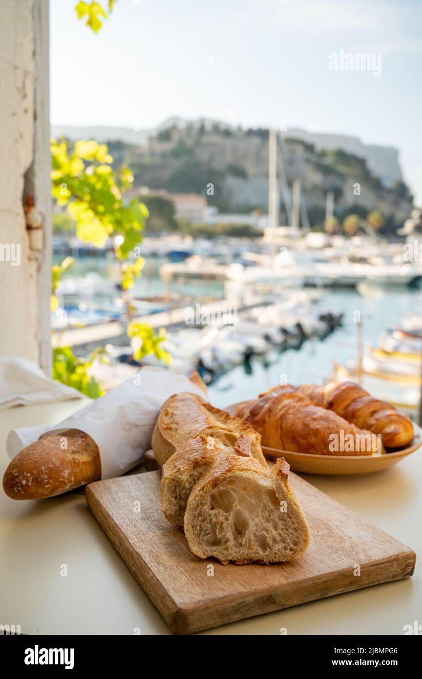 Summer morning in Provence, traditional breakfast with fresh baked croissants and baguette bread ...