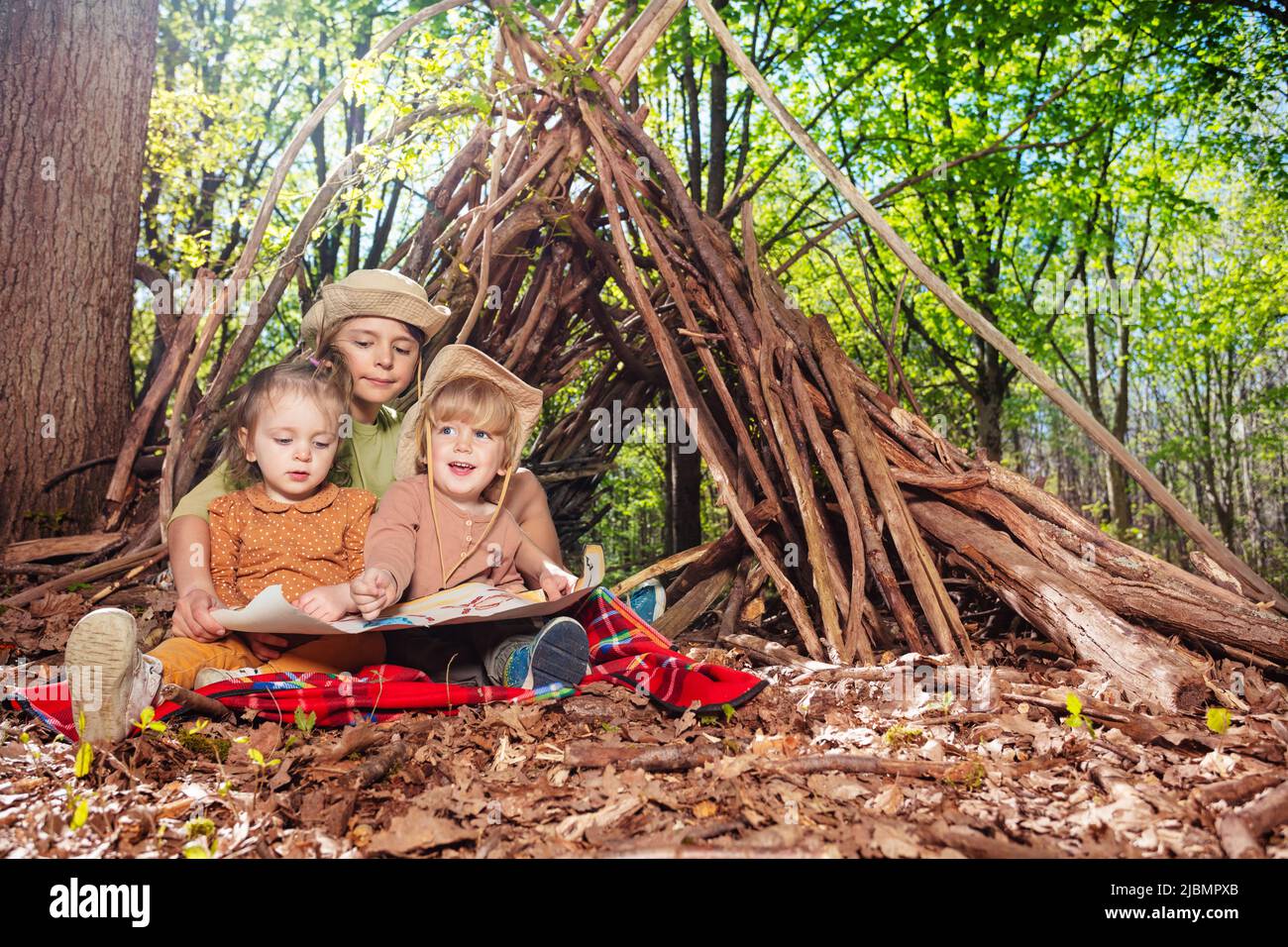 Three children sit with treasury map play treasure hunt Stock Photo - Alamy