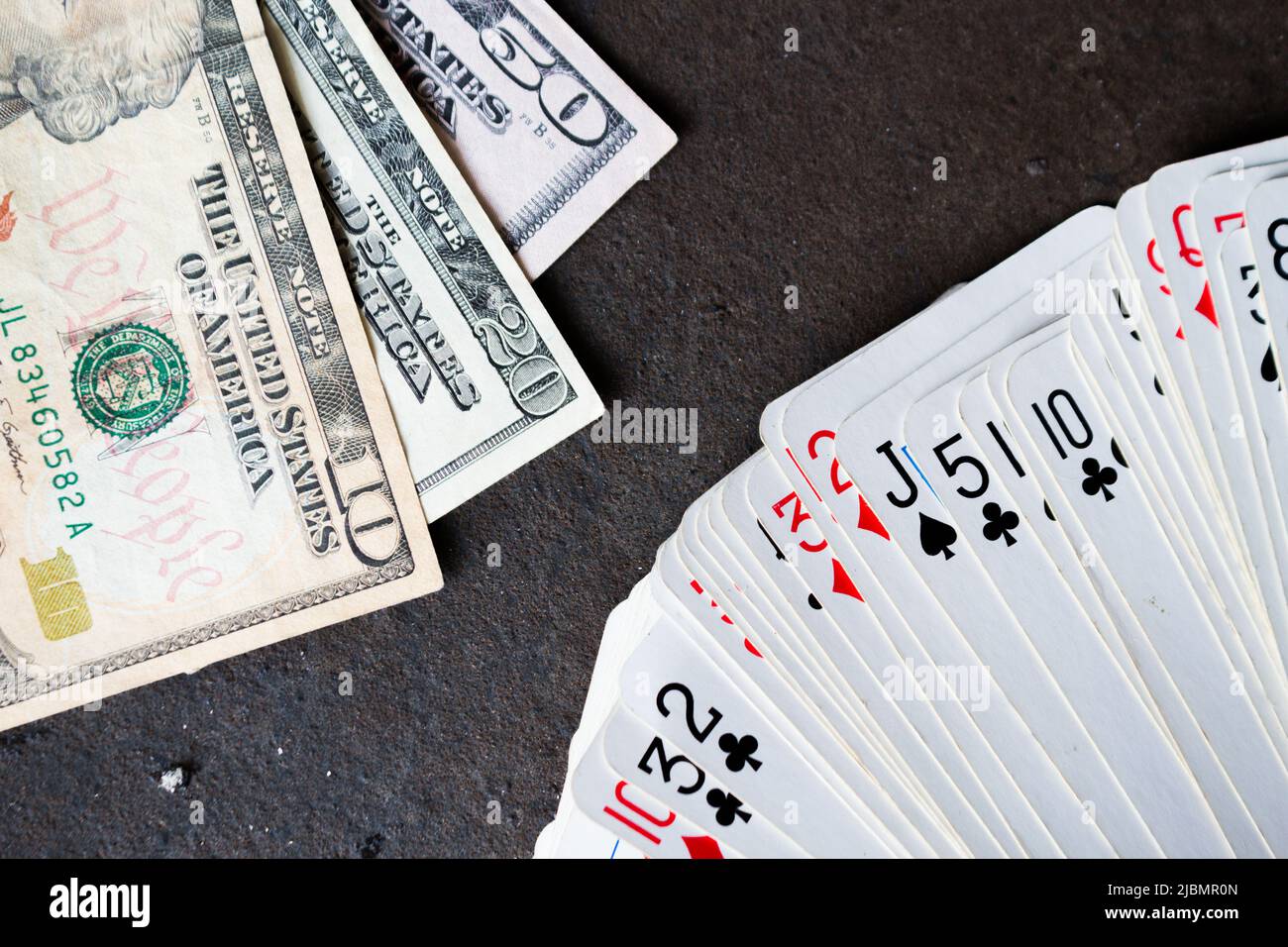 Playing cards and money. Black background Stock Photo - Alamy
