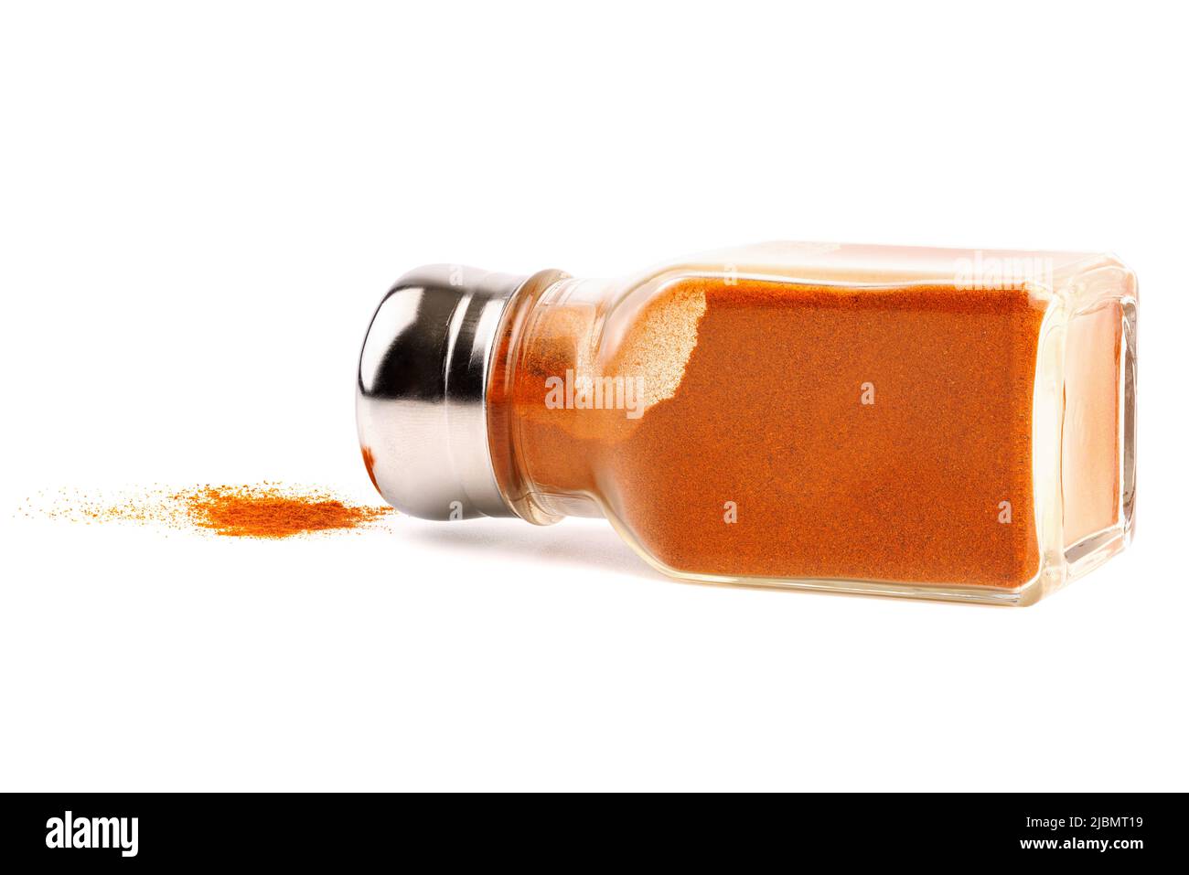glass pepper pot with ground red pepper dropped on its side isolated on ...