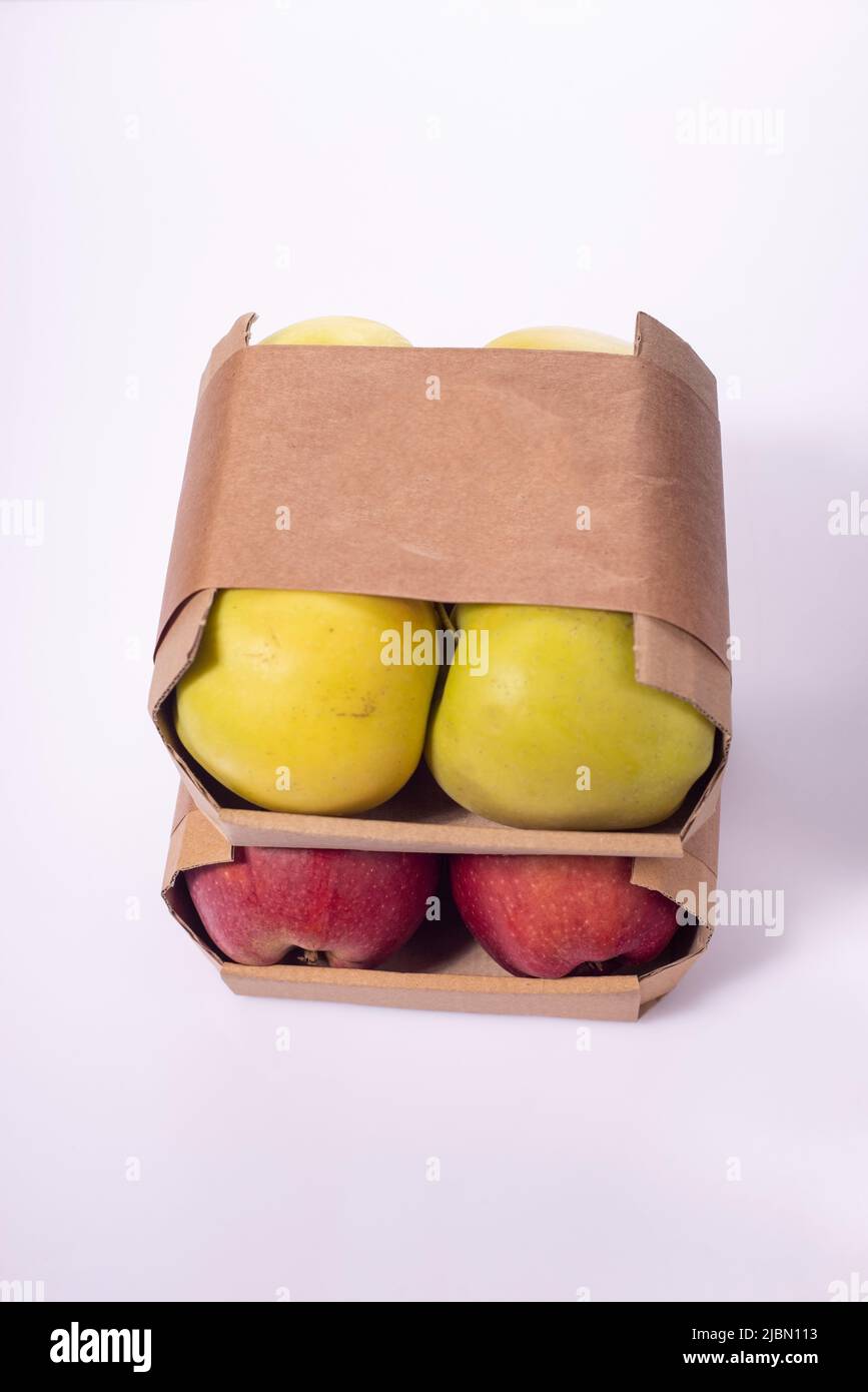 paper packages of yellow and red apples on a white background Stock ...