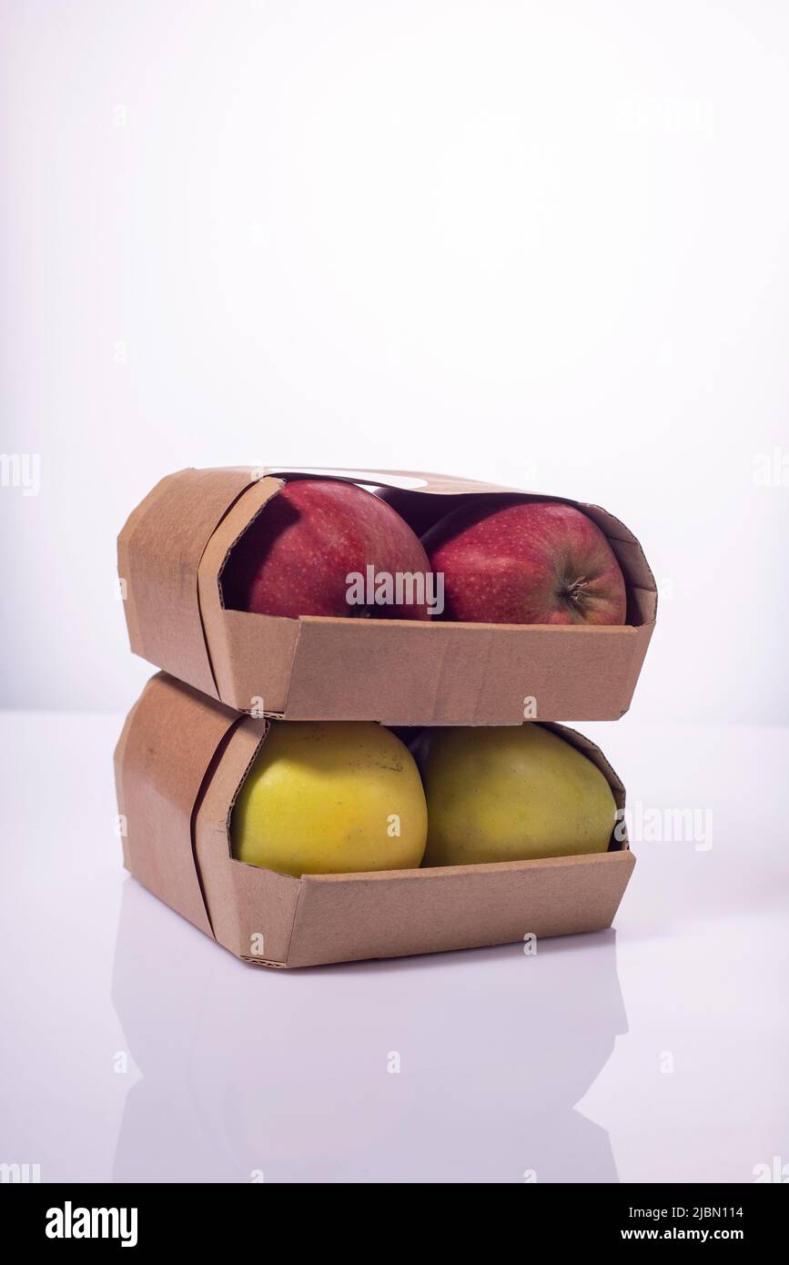 paper packages of yellow and red apples on a white background Stock ...