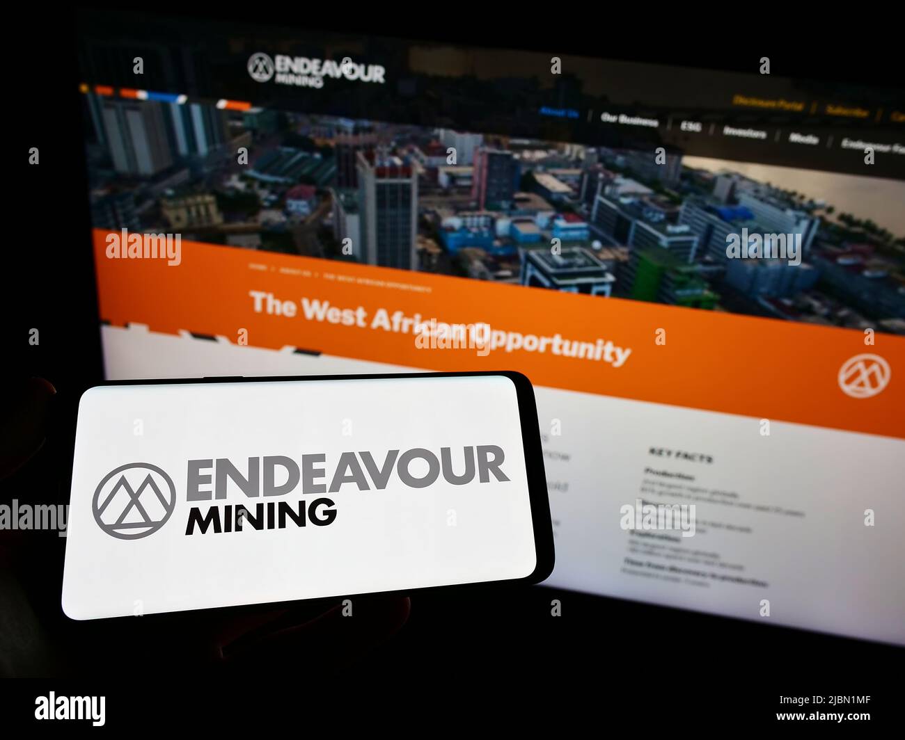 Person holding smartphone with logo of gold exploration company ...