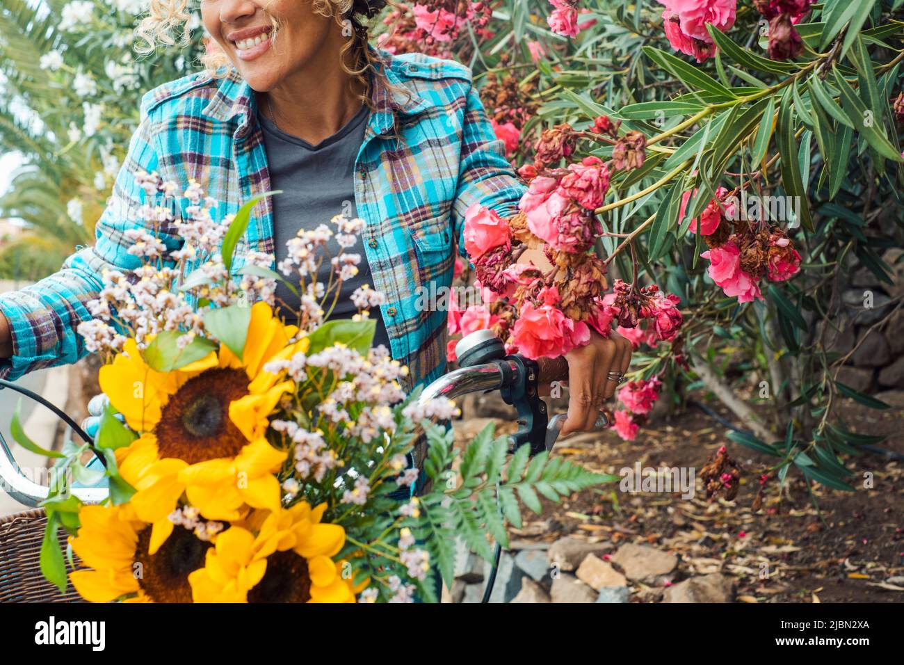 Portrait of woman ona bike and sunflowers. Flower nature background ...