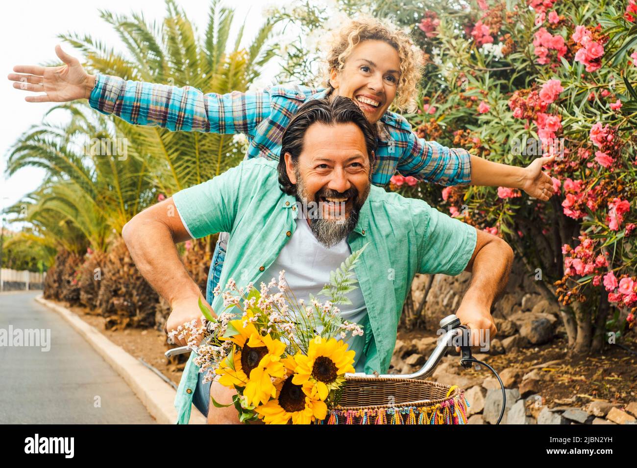 Happy people couple having fun riding a bike together. Man carrying ...