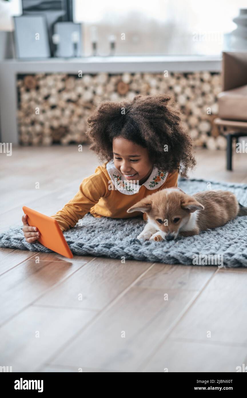 A pretty smiling girl with a puppy making selfie on her device Stock ...