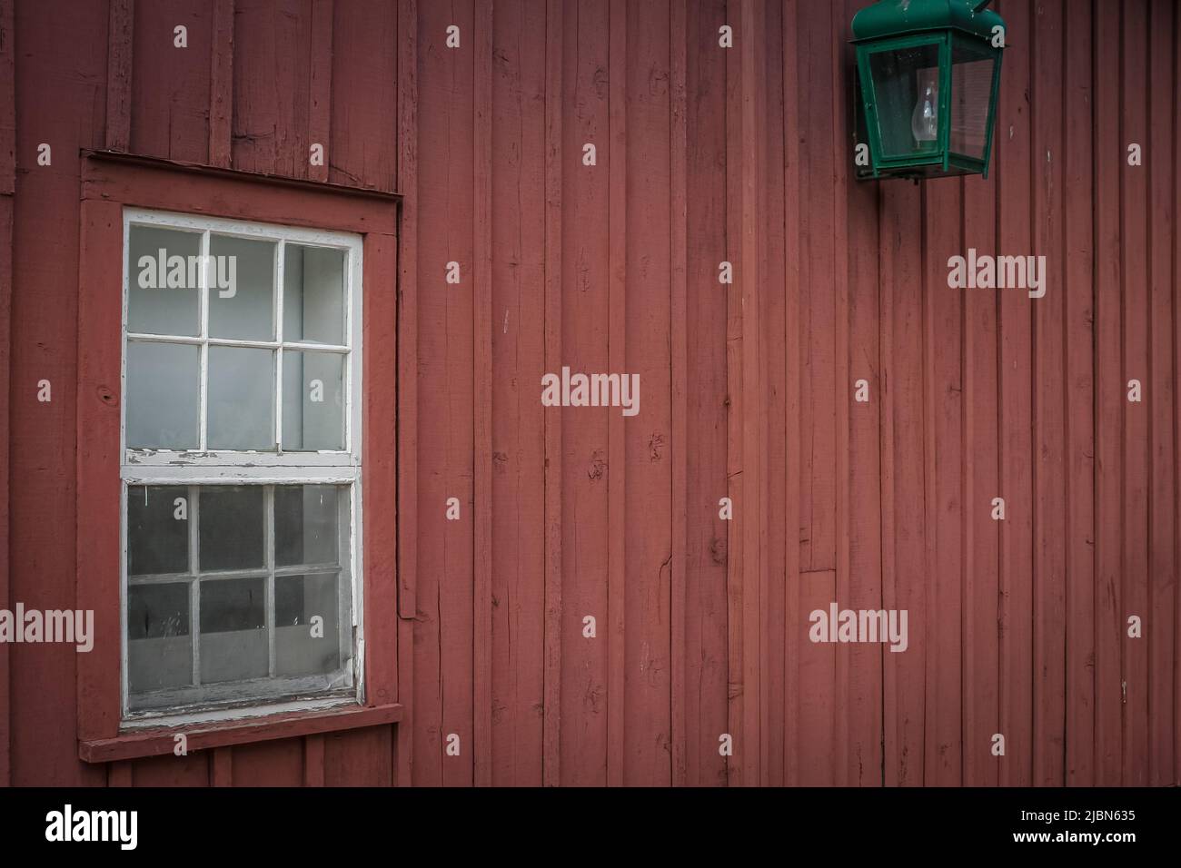 Exterior facade of a wooden barn with a framed glass window and an old ...