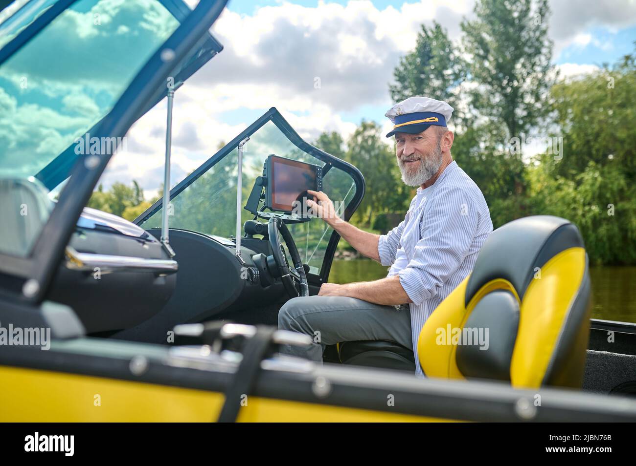 A man in a captains cap getting the boat ready Stock Photo - Alamy