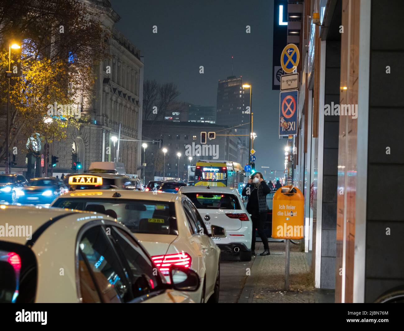 Night photograph of a taxi car. Taxi sign on the car roof glows in the ...